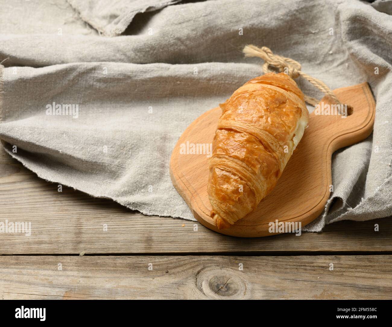 baked croissant on wooden board, wooden gray table, close up, top view ...