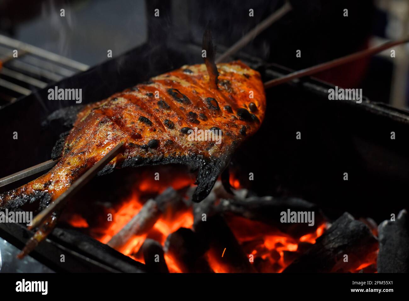 Masala fish been grilled on hot coals. Versova seafood festival, 2020 ...
