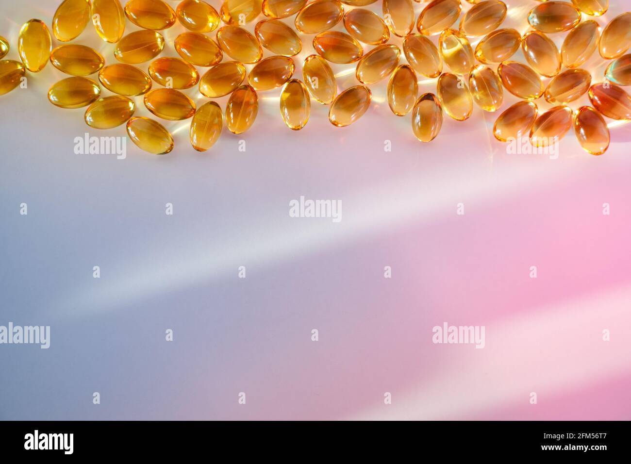 beauty capsules with light reflexes on pink and blue background Stock ...