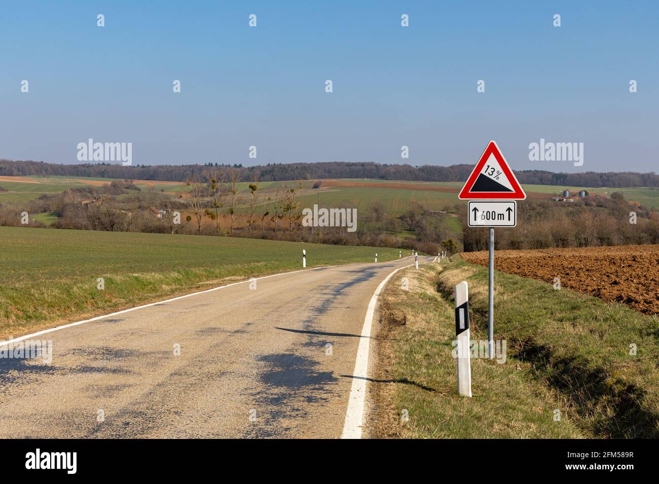 Landscape with road and road sign - inclined road Stock Photo - Alamy