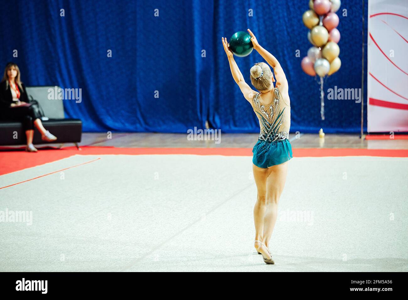 a gymnast girl performs with a hoop. flexible athlete performs a ...