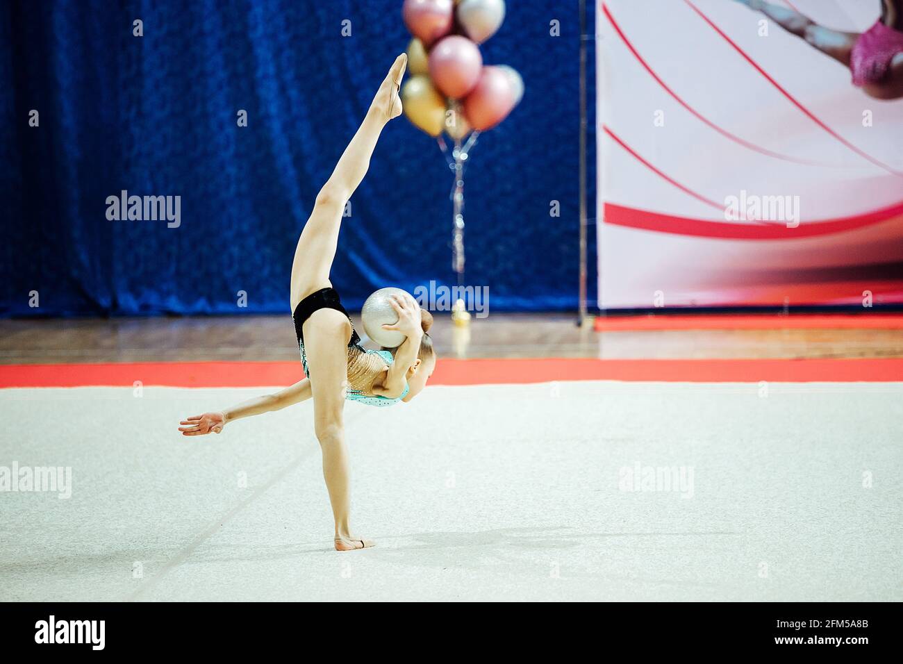 a gymnast girl performs with a hoop. flexible athlete performs a ...