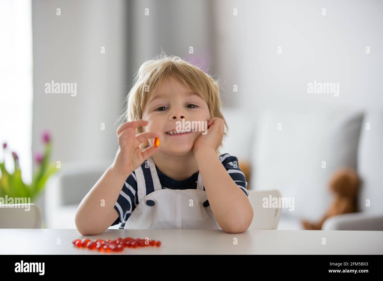 Cute little child, toddler boy, eating alfa omega 3 child supplement ...