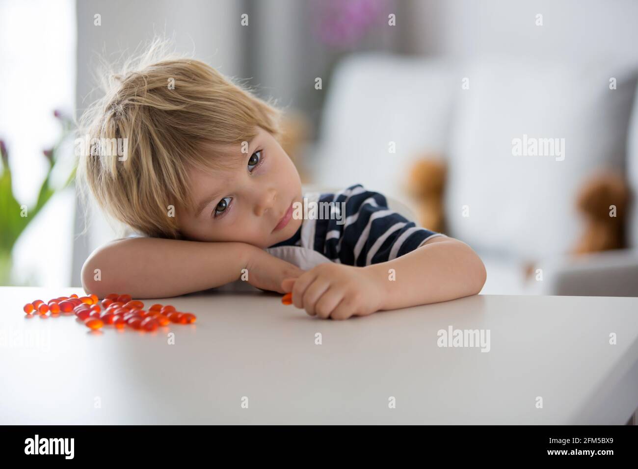 Cute little child, toddler boy, eating alfa omega 3 child supplement ...
