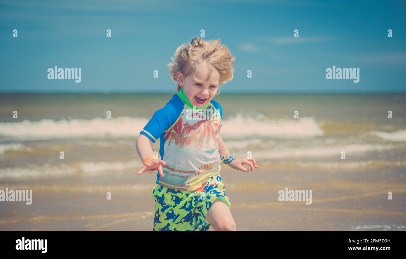 Young Boy playing on beach Stock Photo - Alamy