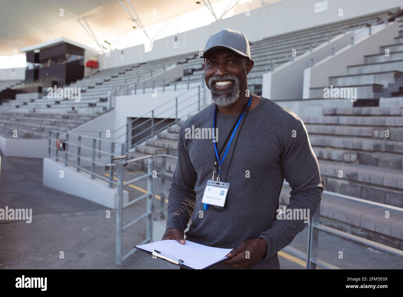 Portrait of african american male coach holding clipboard smiling while ...