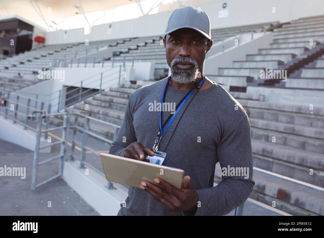 Portrait of african american male coach holding clipboard standing in ...