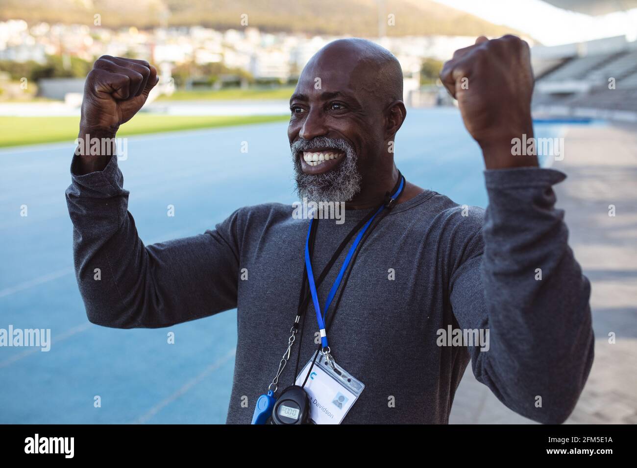 Happy african american senior male coach cheering while standing in the ...