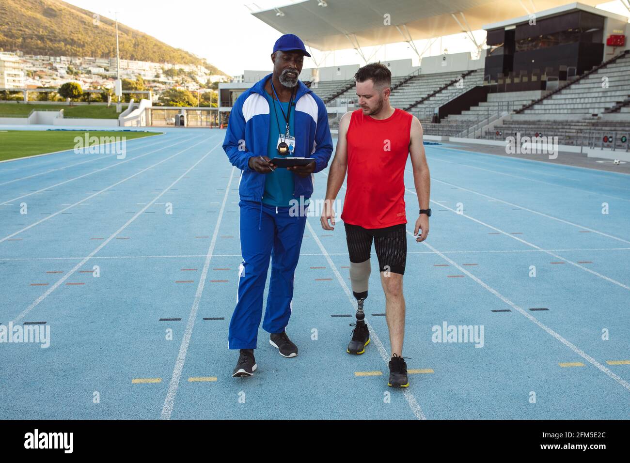 African american male coach instructing caucasian male athlete with ...