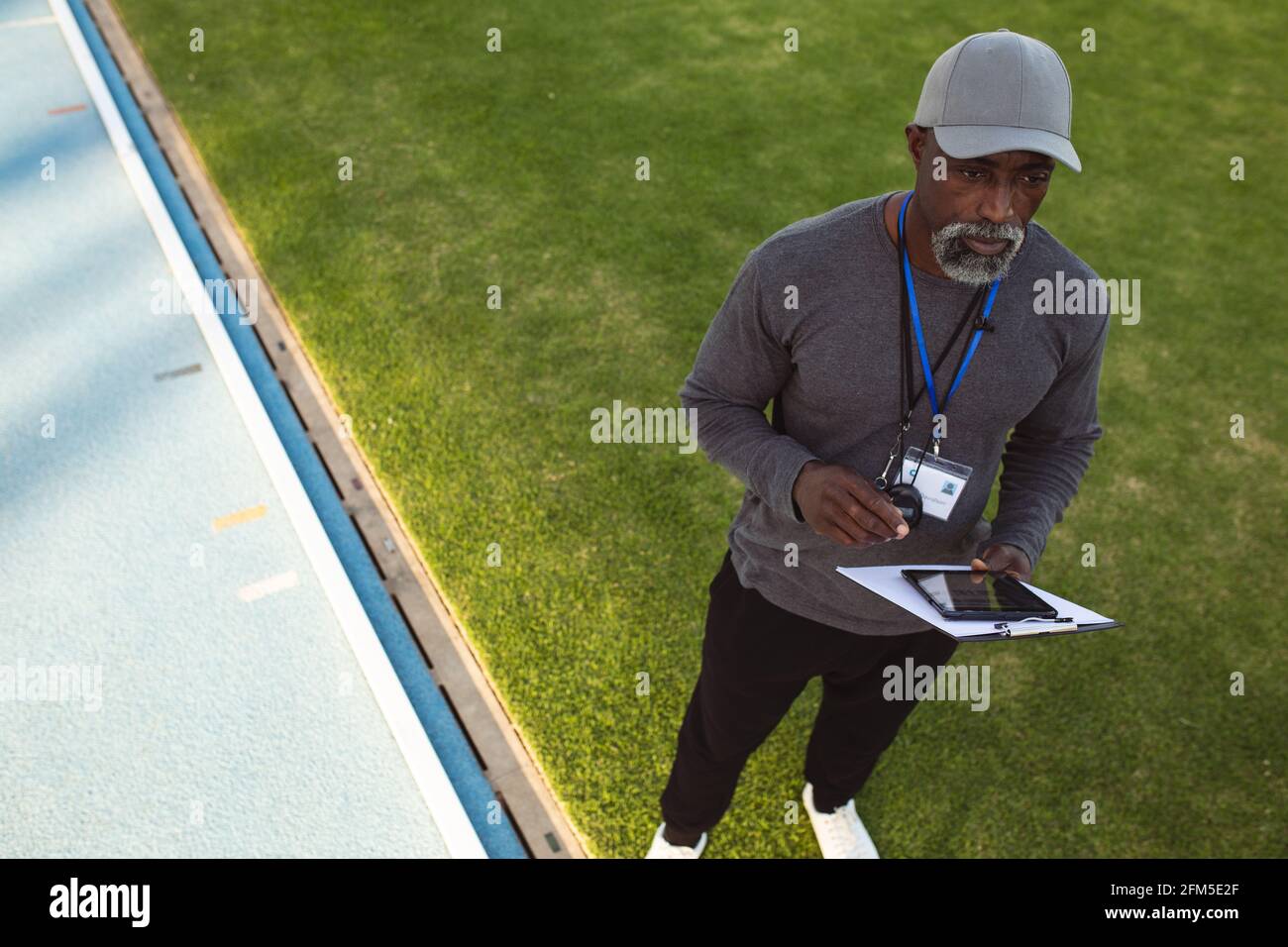 African american male coach with clipboard and digital tablet standing ...