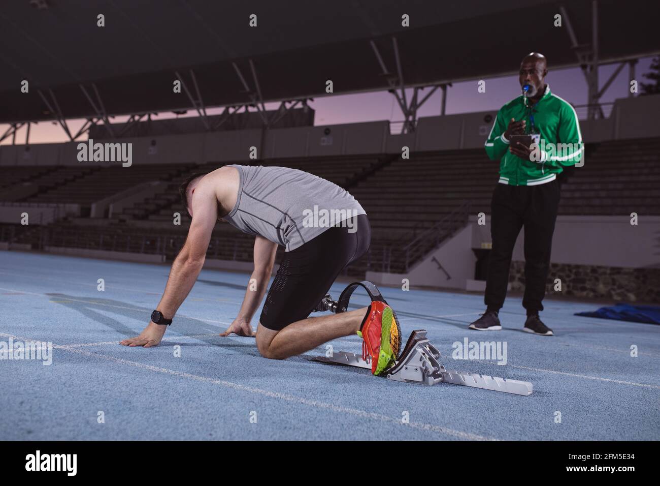 Caucasian male athlete with prosthetic leg in starting position for ...