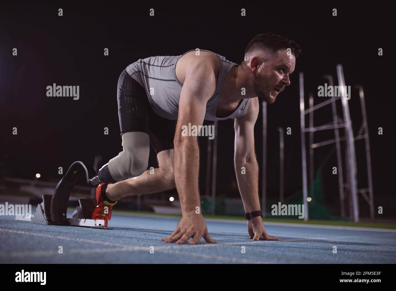 Caucasian male athlete with prosthetic leg in starting position for ...