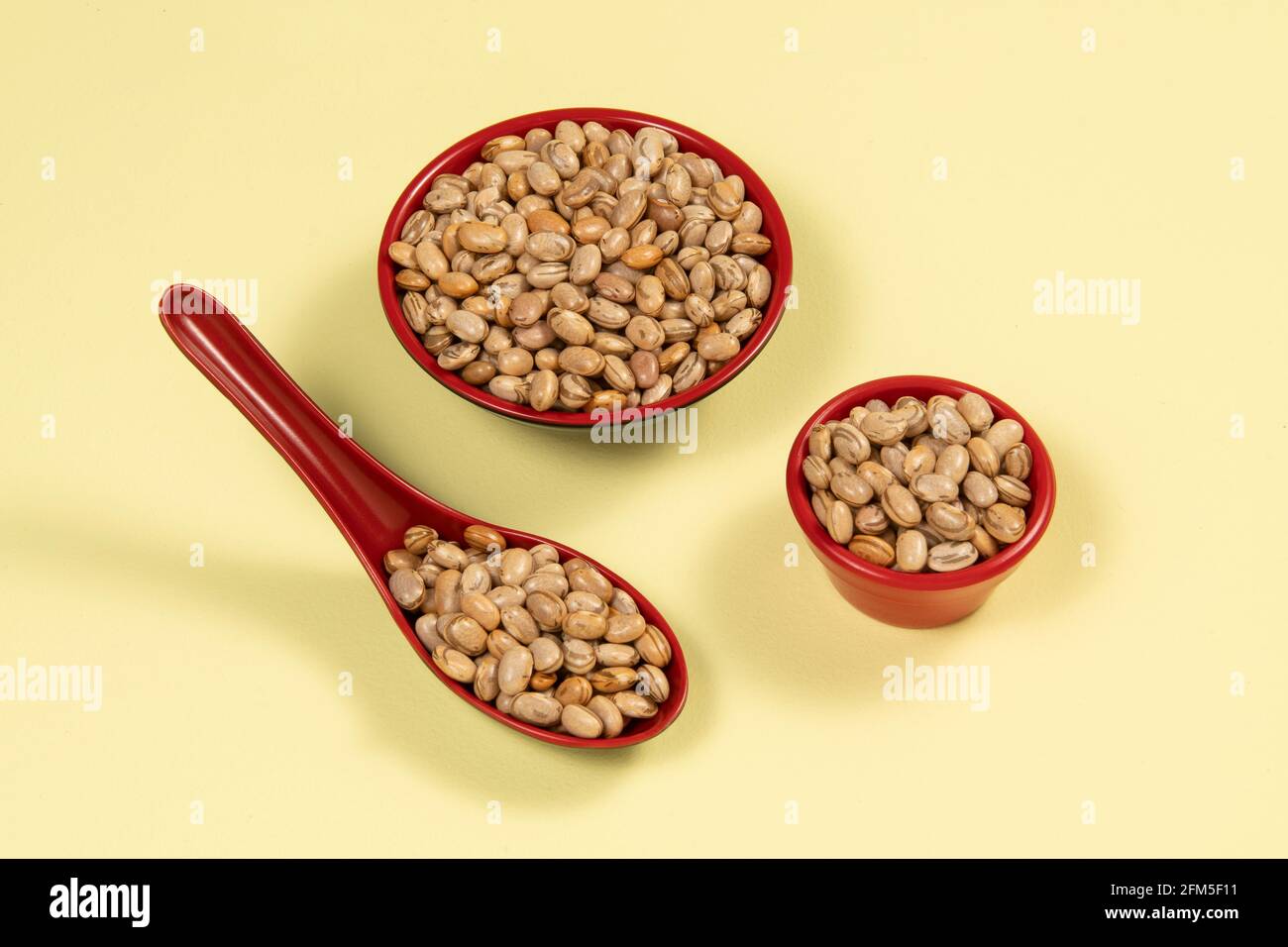 Dry pinto bean seed in red plastic bowl, high angle of view Stock Photo ...
