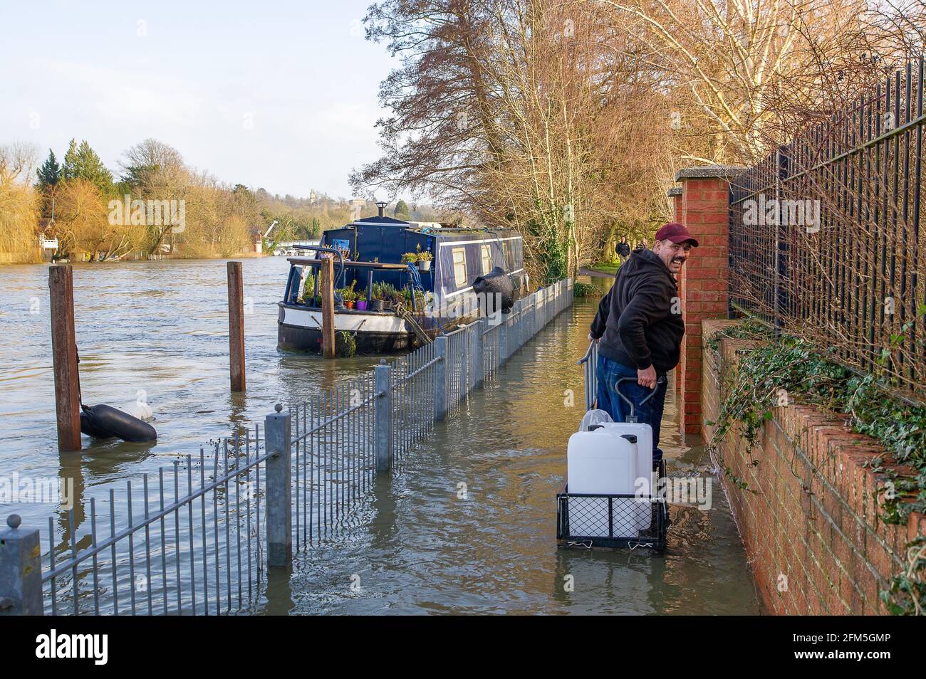 Cookham, Berkshire, UK. 2nd February, 2021. A boat dweller goes to get ...
