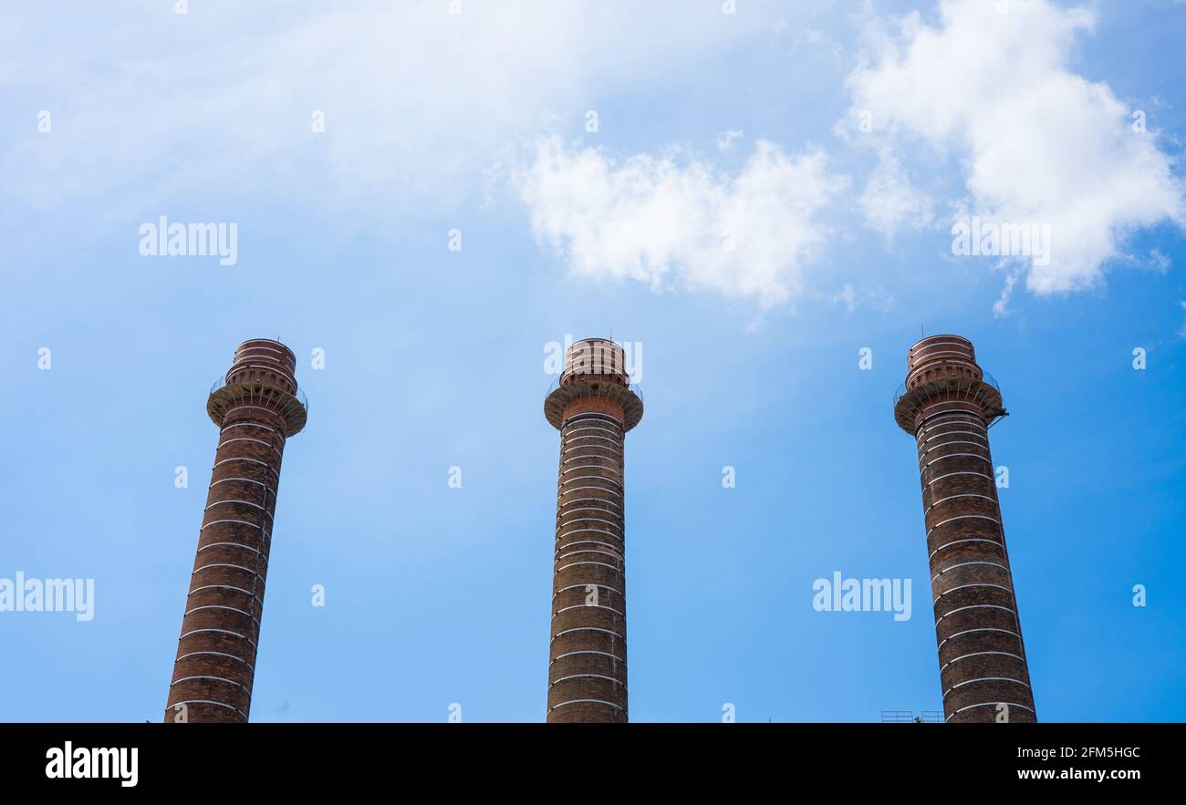 three brick industrial factory chimneys Stock Photo - Alamy