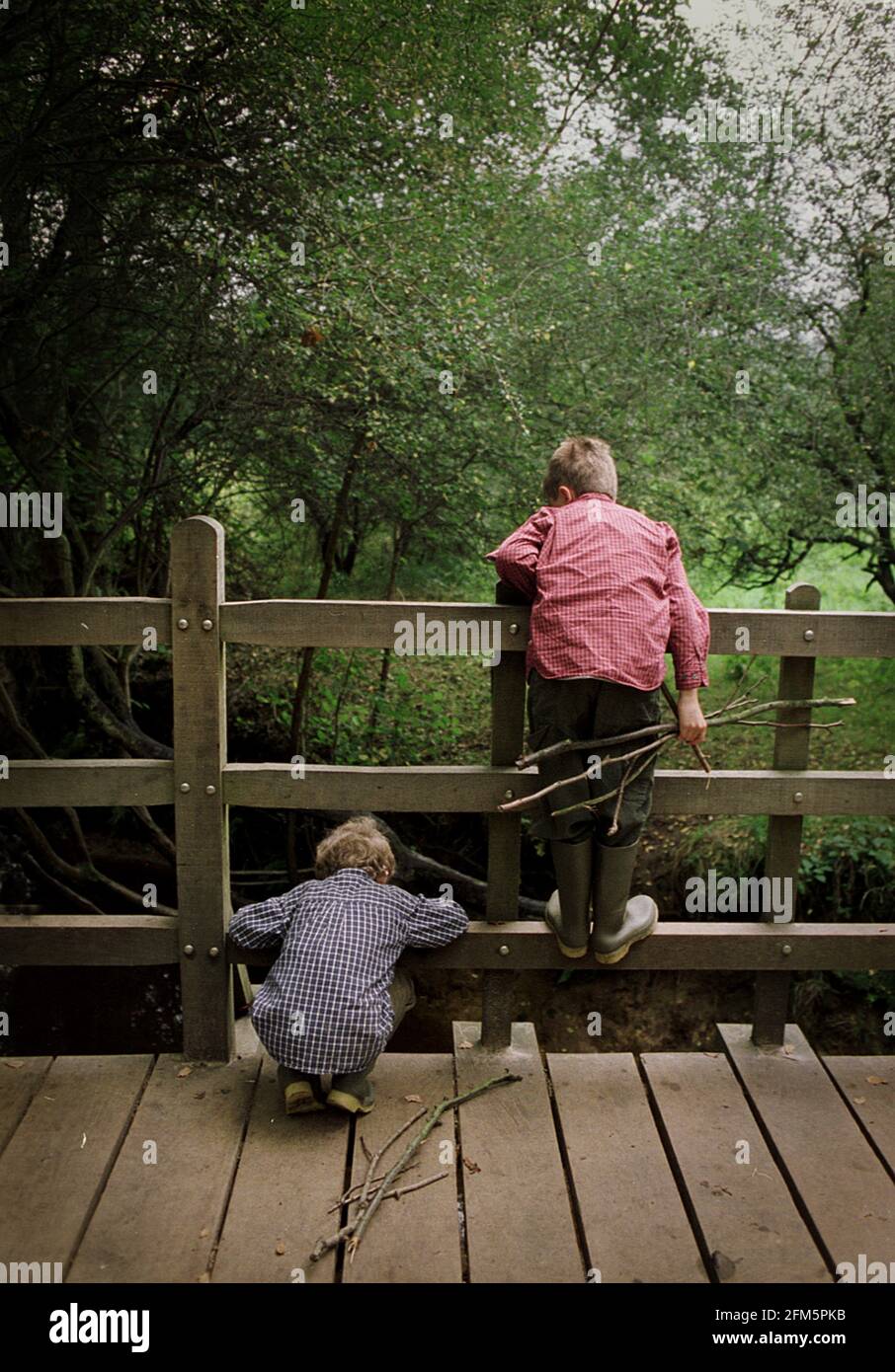 ON ITS THE 75 ANNIVERSARY ,TWO CHILDREN PLAY POOH STICKS ON POOH BRIDGE ...