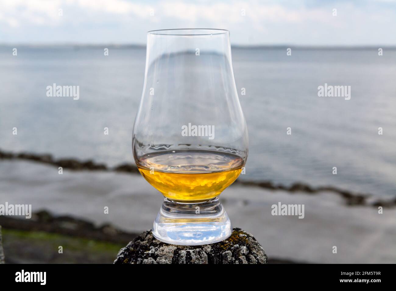 Tasting of dram single malt scotch whisky on seashore in Scotland, old ...