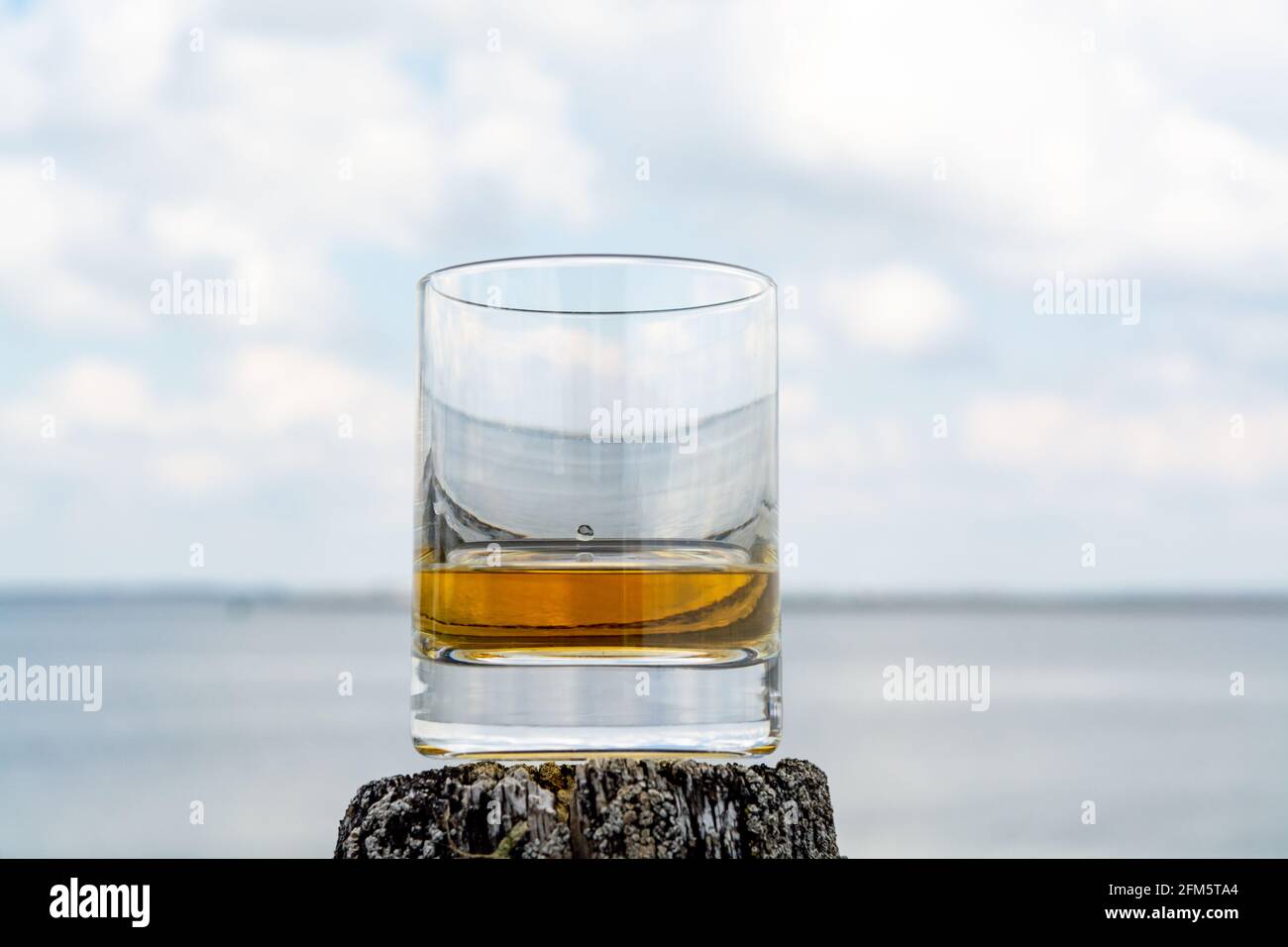 Tasting of dram single malt scotch whisky on seashore in Scotland, old ...