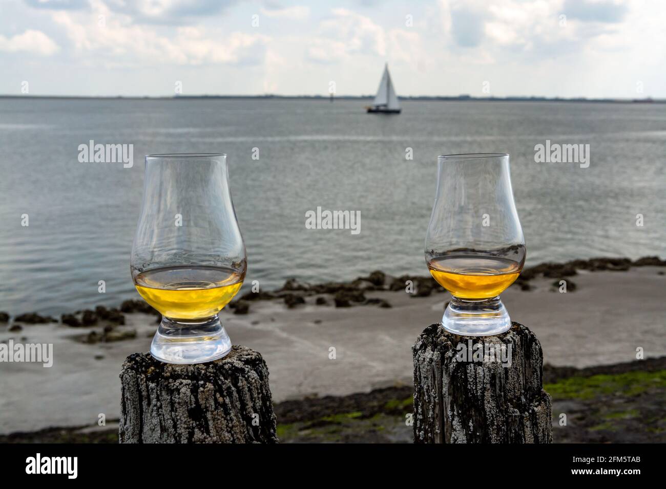 Tasting of dram single malt scotch whisky on seashore in Scotland, old ...