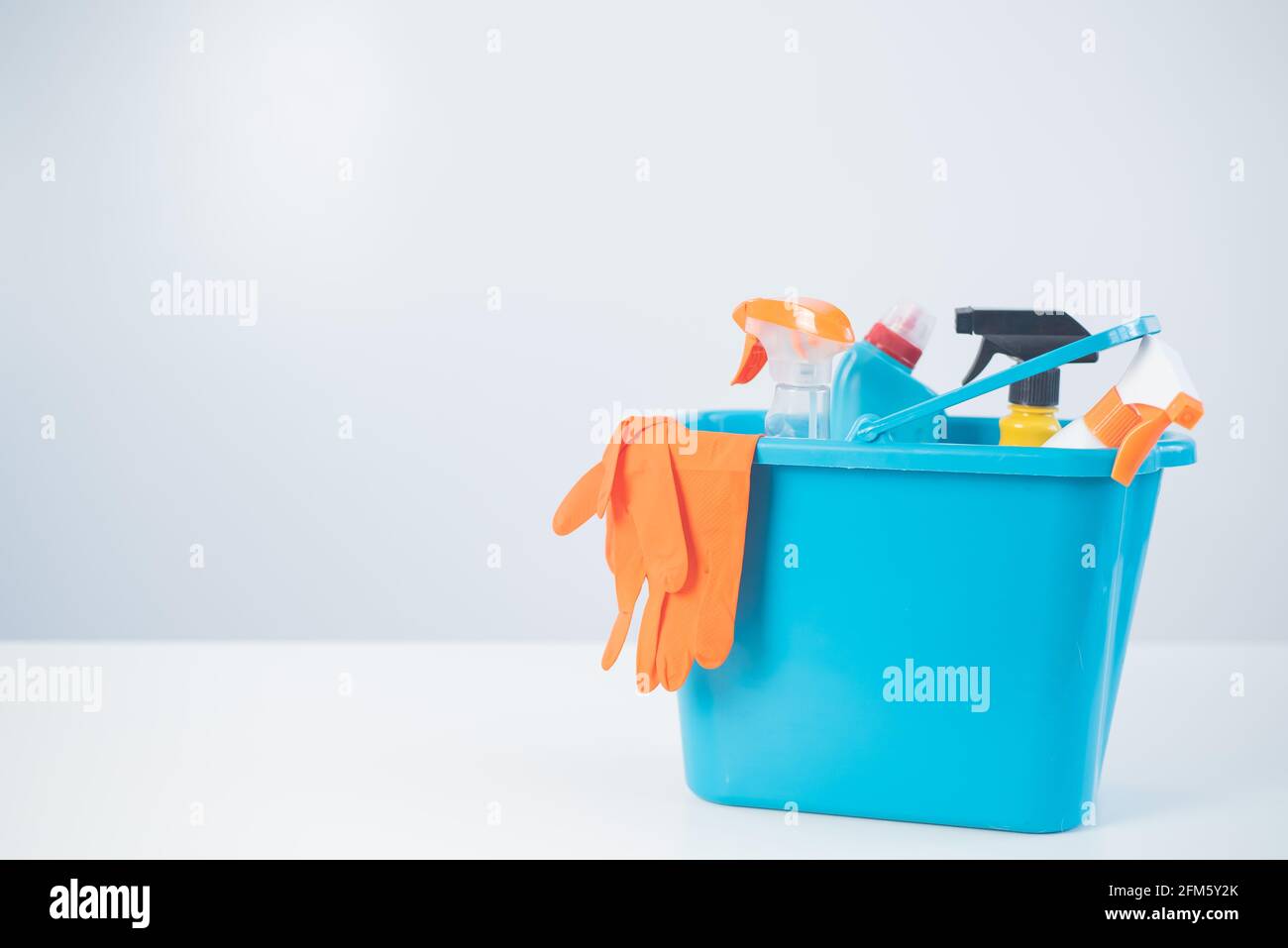 Blue bucket with cleaning products and rubber gloves for homework on a ...