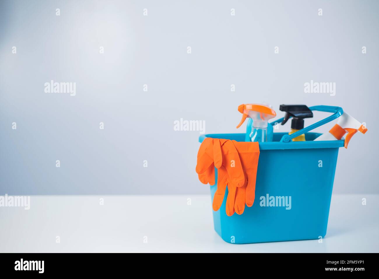 Blue bucket with cleaning products and rubber gloves for homework on a ...