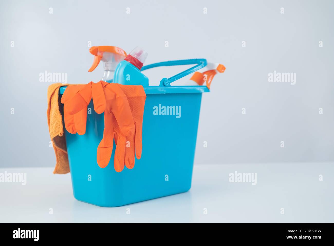Blue bucket with cleaning products and rubber gloves for homework on a ...