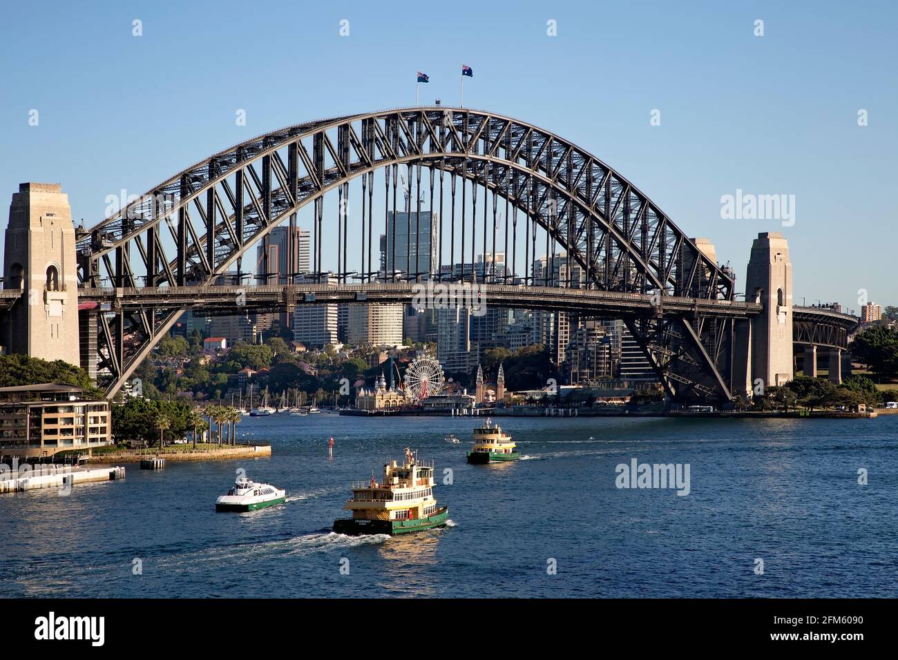 Sydney Harbour Bridge with Luna Park in the background and ferries ...