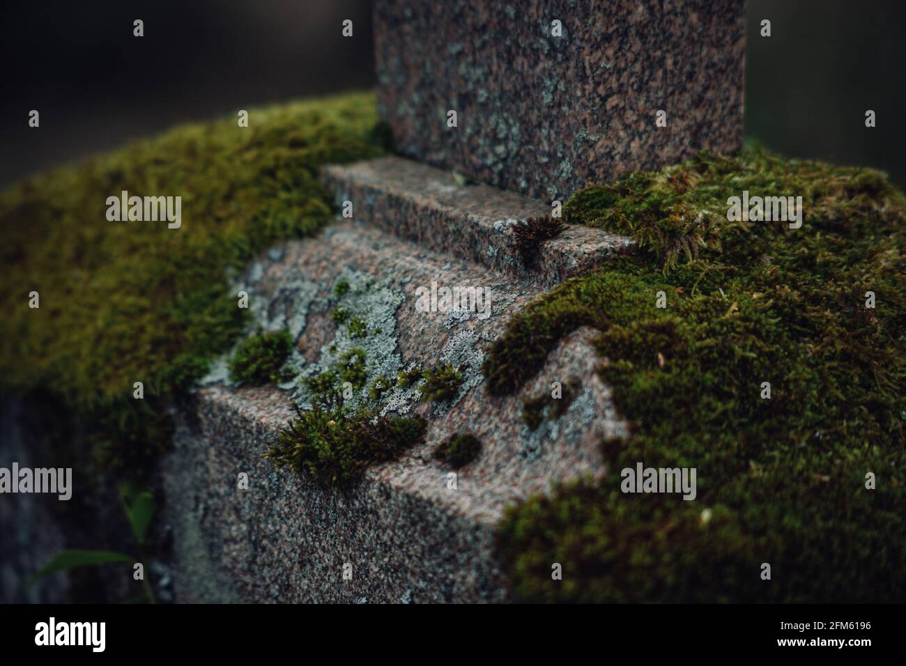base of a large granite tombstone grave marker in a cemetery. Natural ...