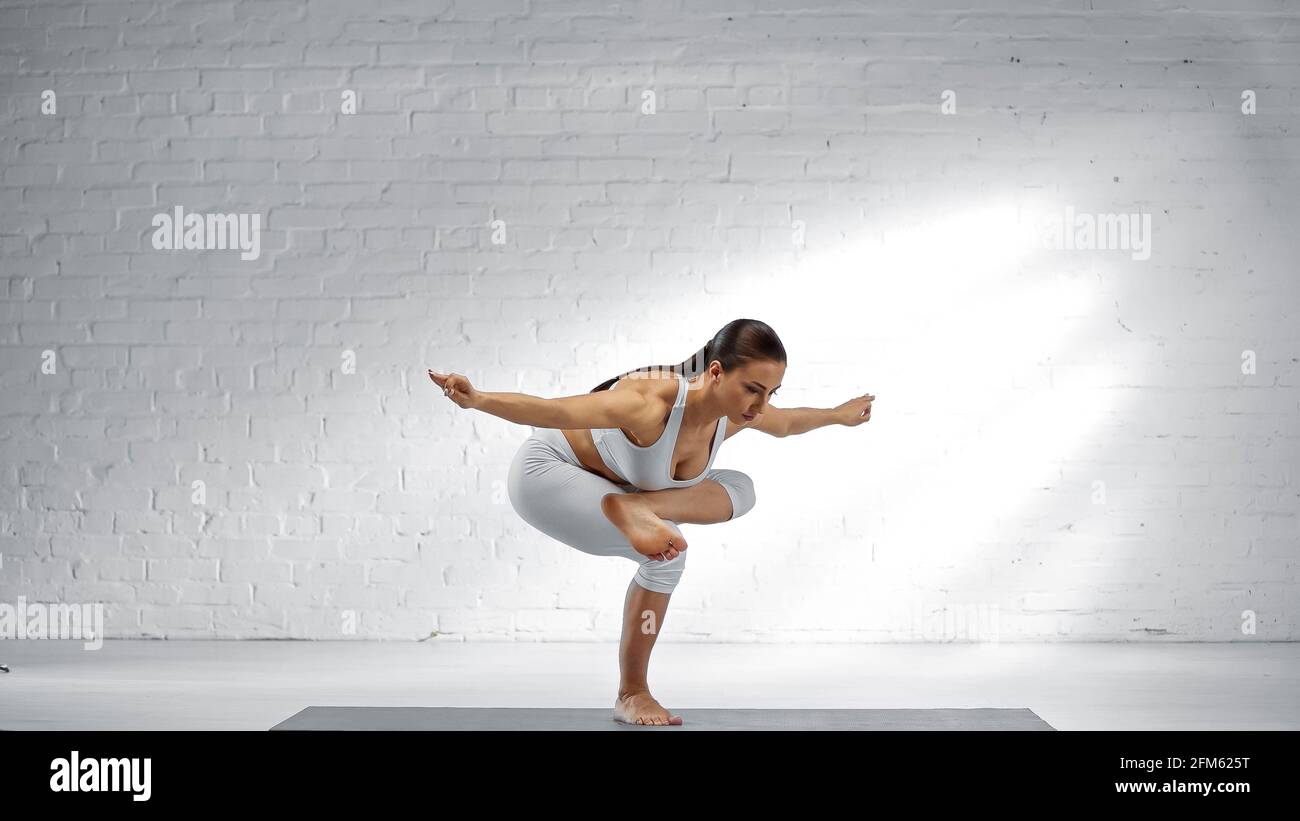 Fit woman balancing on one leg while doing yoga pose Stock Photo - Alamy