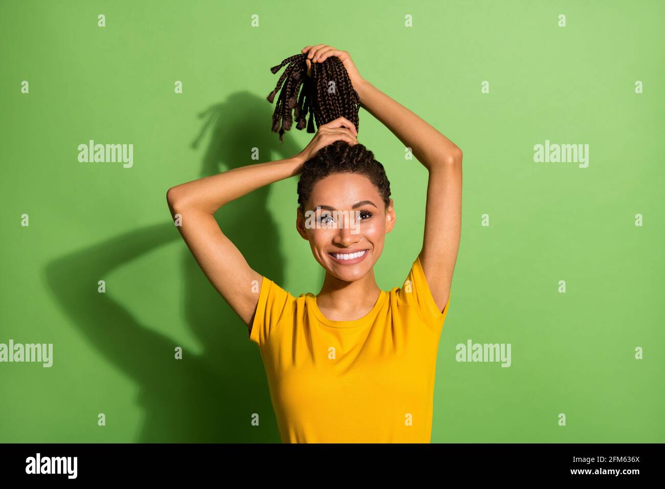 Portrait of charming cheerful funky girl having fun making hairdo care ...