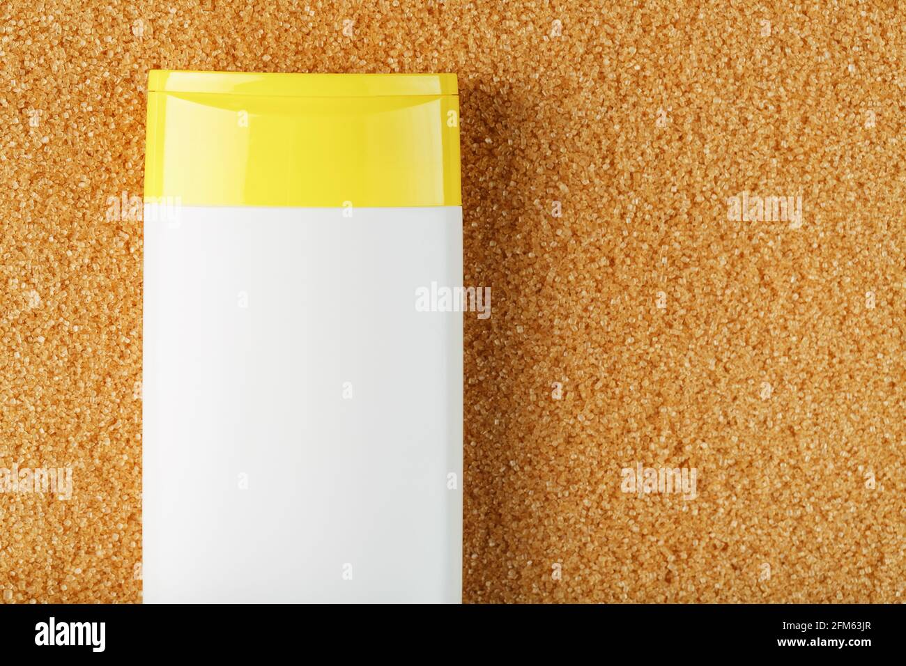 Sunscreen in a white bottle with a yellow cap on the golden sand. Free ...