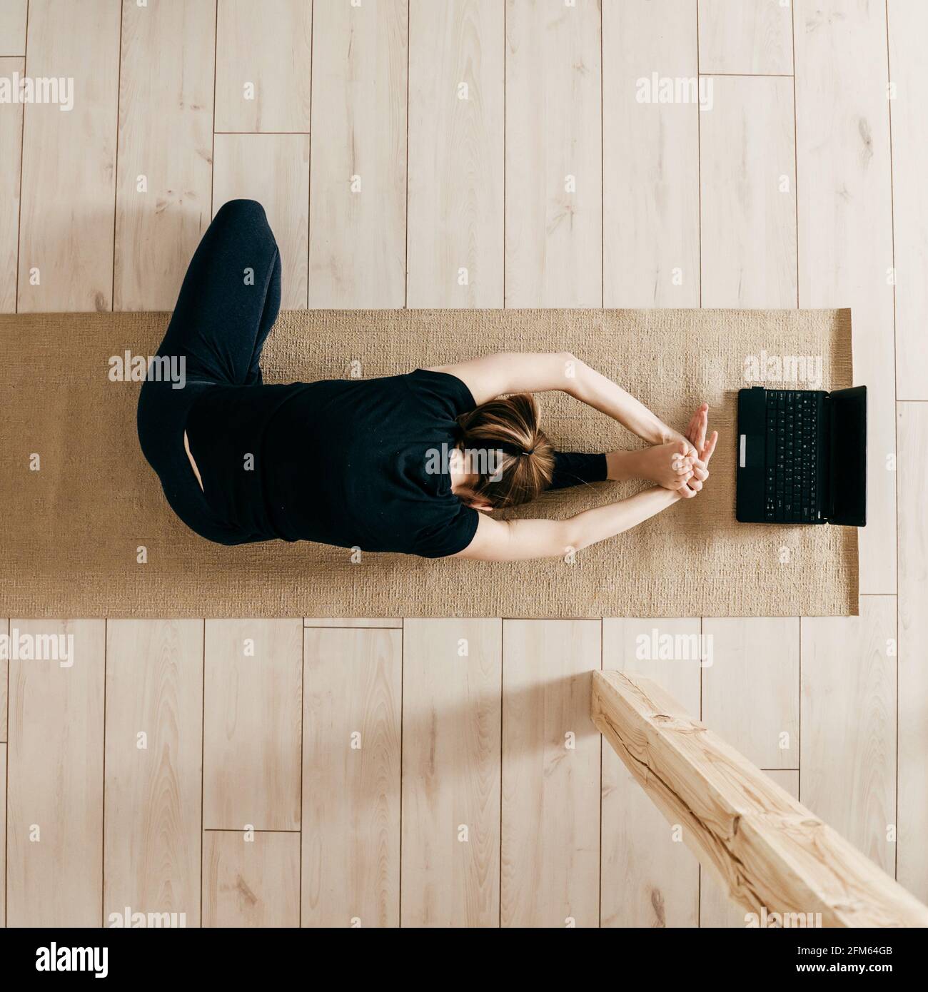 Top view of woman woman practicing yoga indoor. Woman curls up and ...