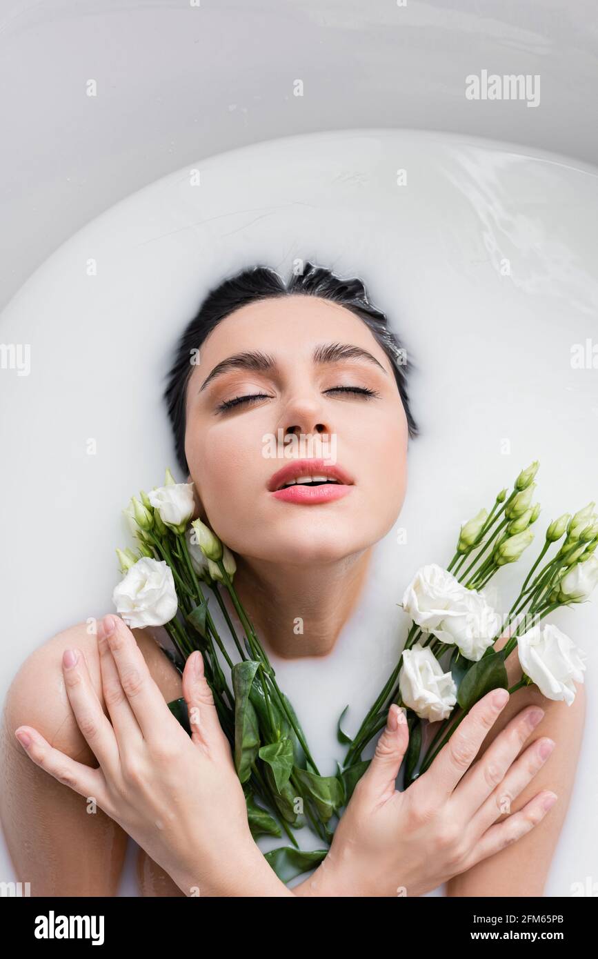seductive woman with eustoma flowers enjoying bathing in milk Stock ...