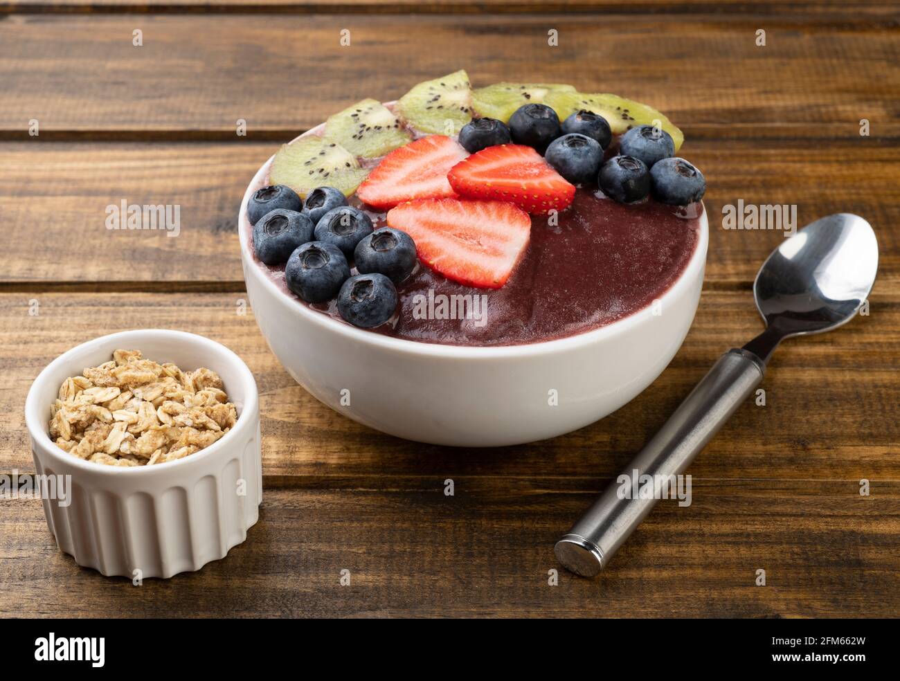 Brazilian typical acai bowl with kiwi, blueberry and strawberry over ...