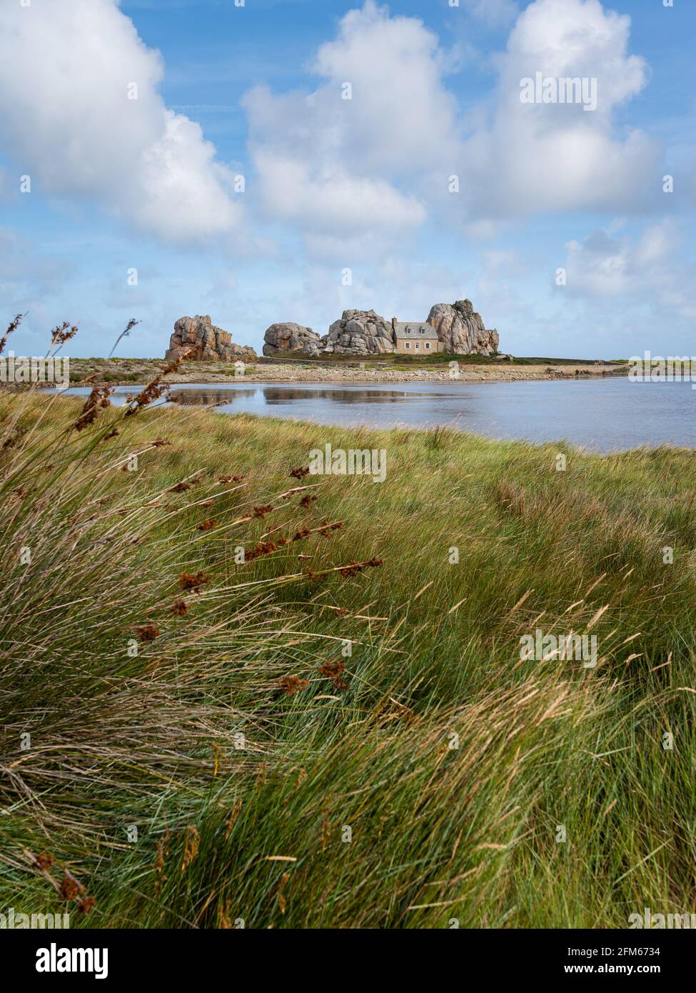 A small stone house built between rocks near the sea, sunny day in ...