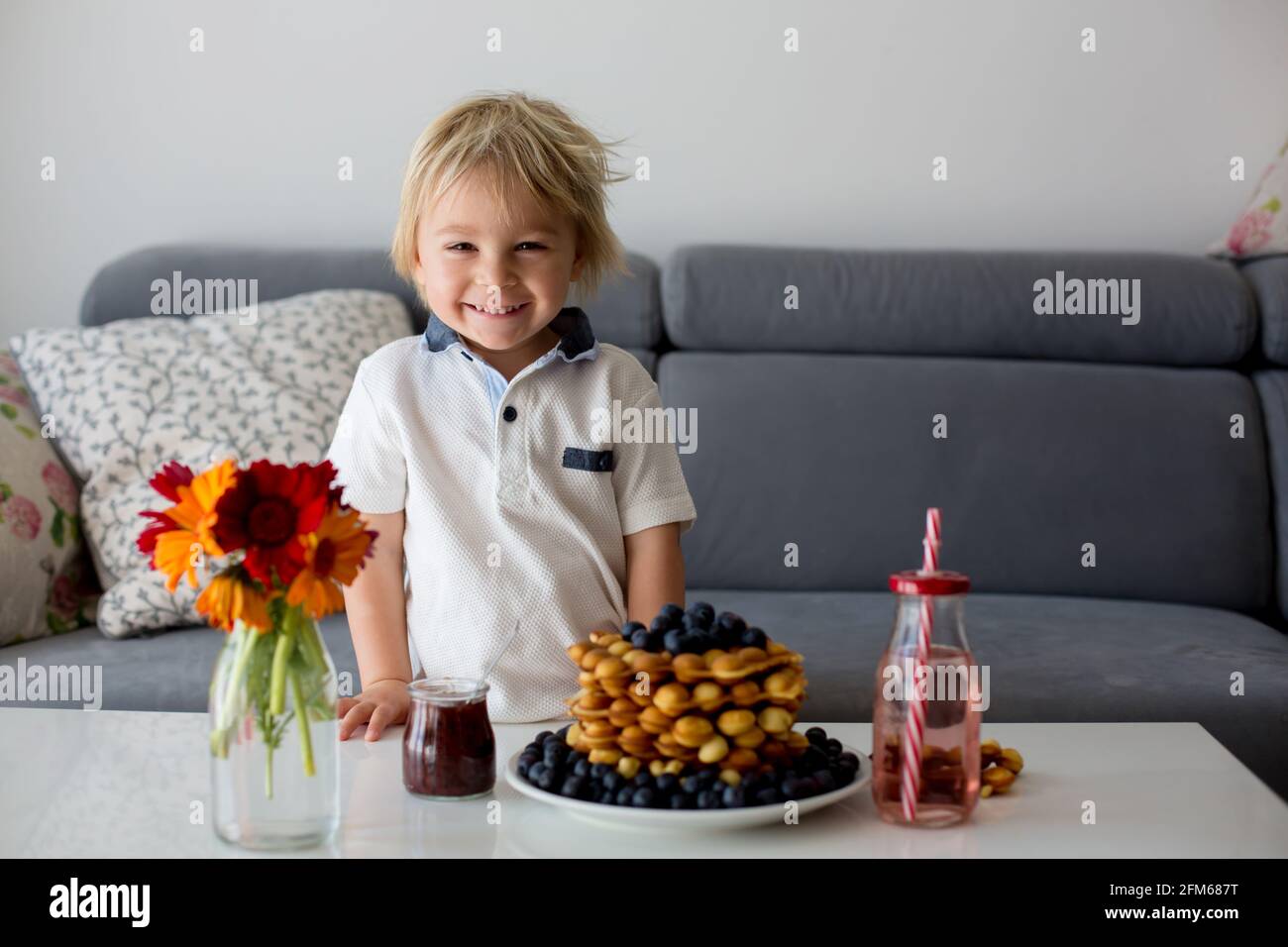 Sweet toddler child, boy, eating bubble waffles with fruits at home for ...