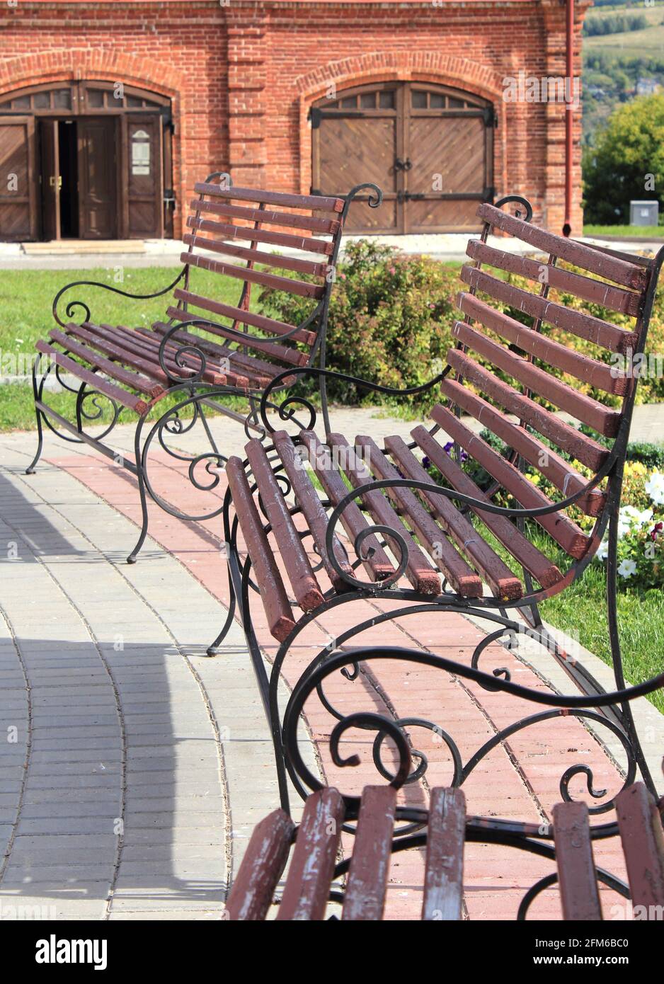 Close-up wooden benches with wrought iron railings stand in a ...