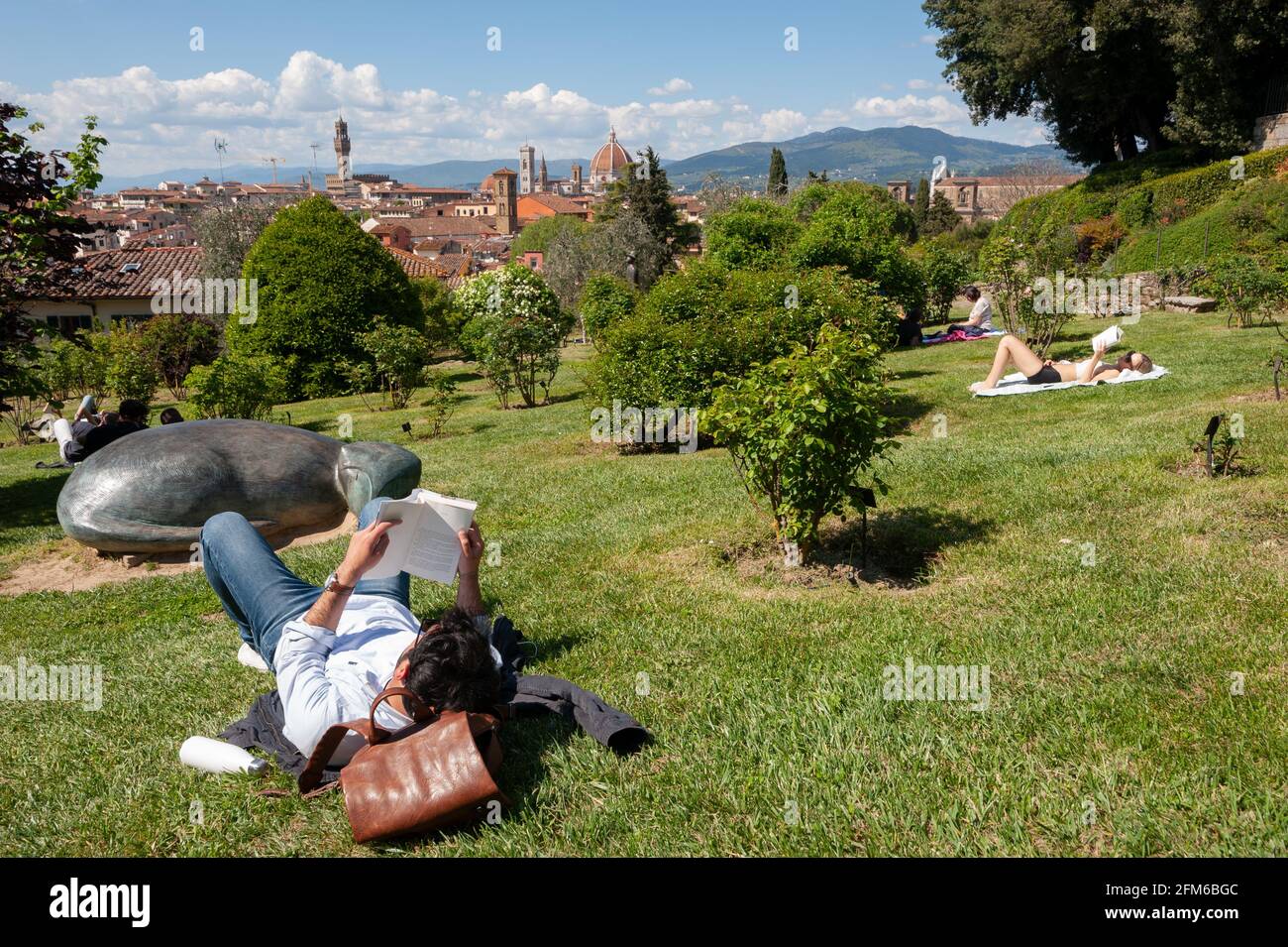 Reading a book, lying on the lawn, at the Giardino delle Rose (near ...