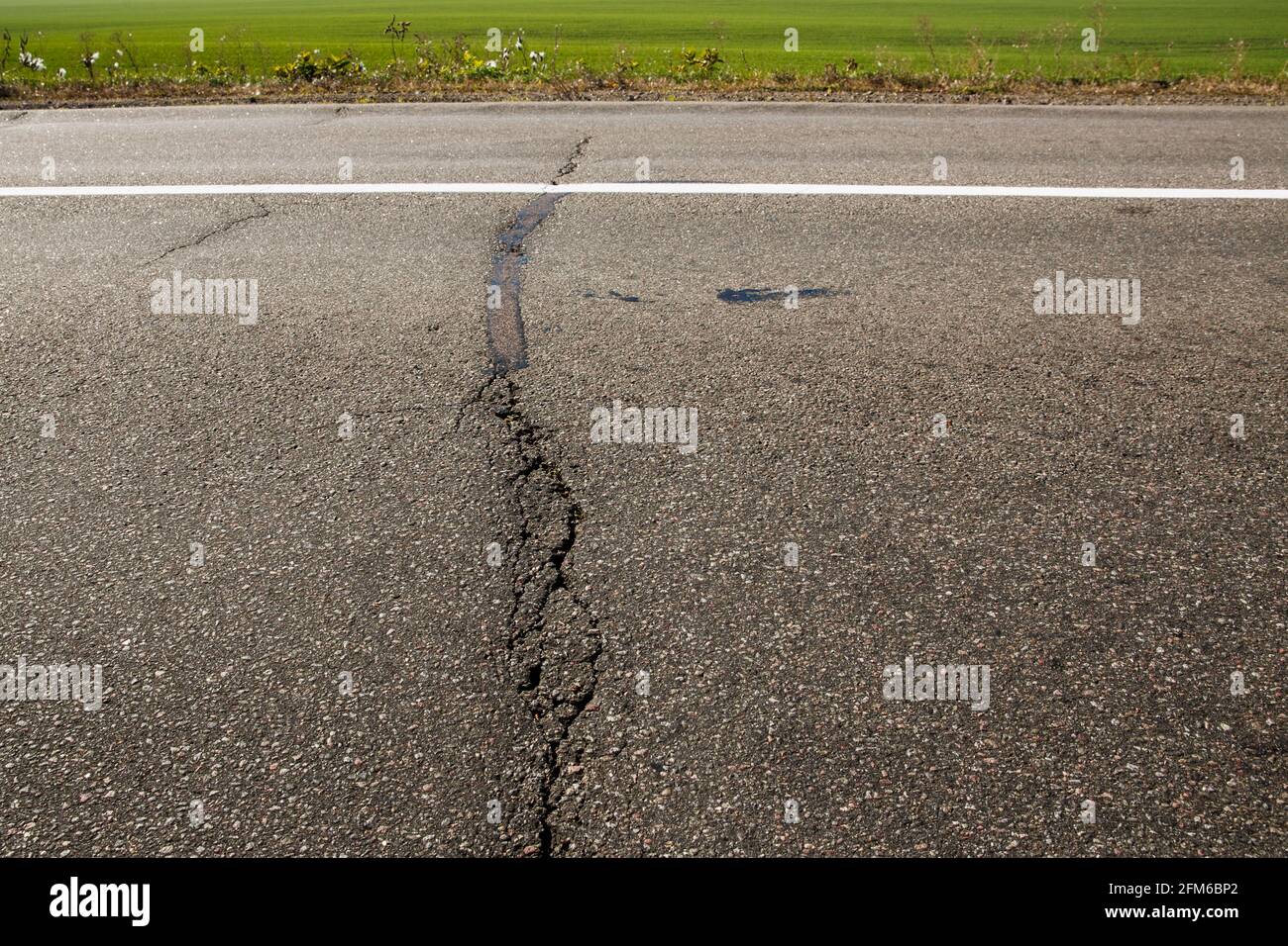 Old asphalt road. Driving on an empty road. Cracked white line on the ...