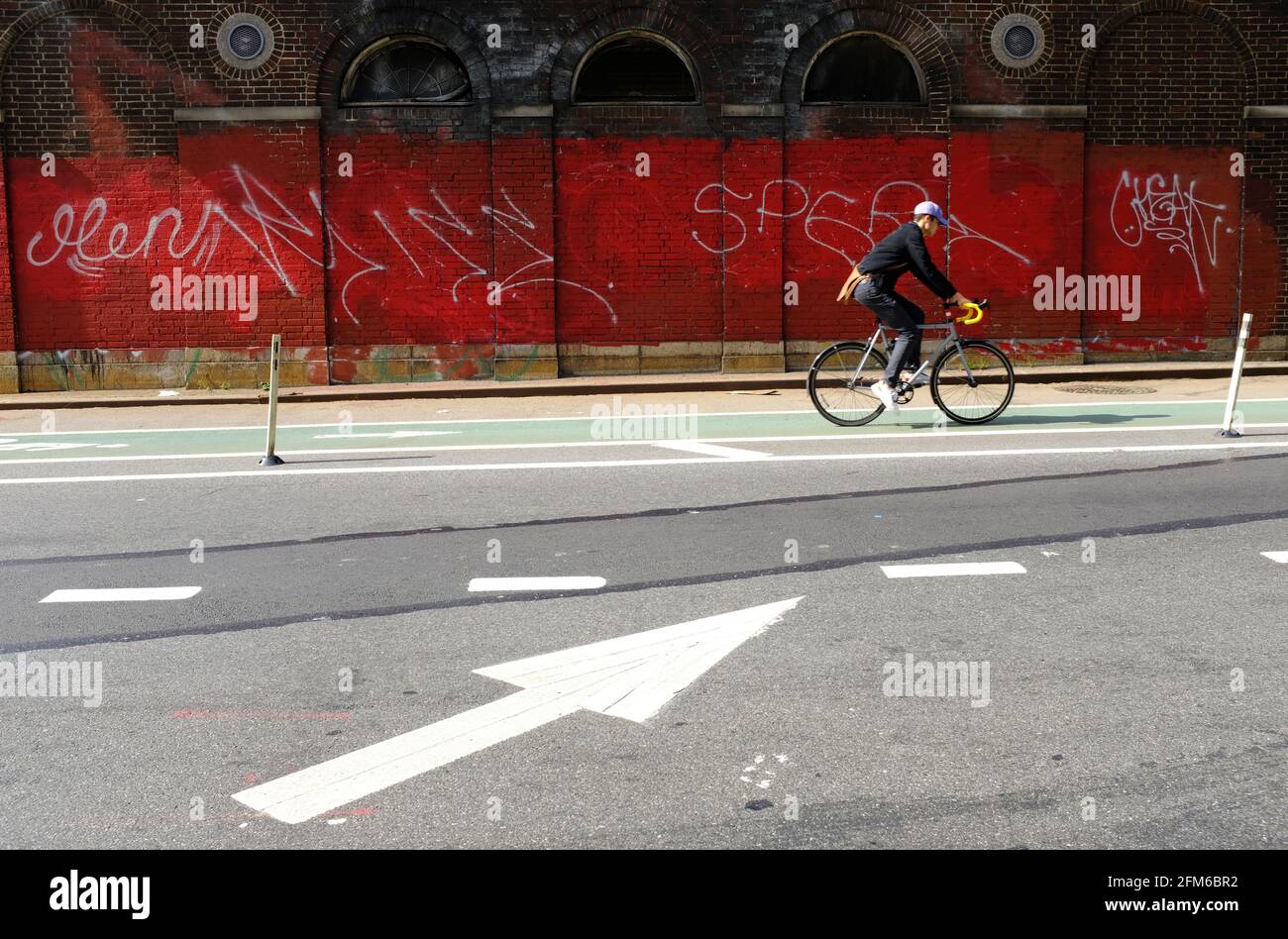 A cyclist riding on bike line with a white arrow point traffic ...