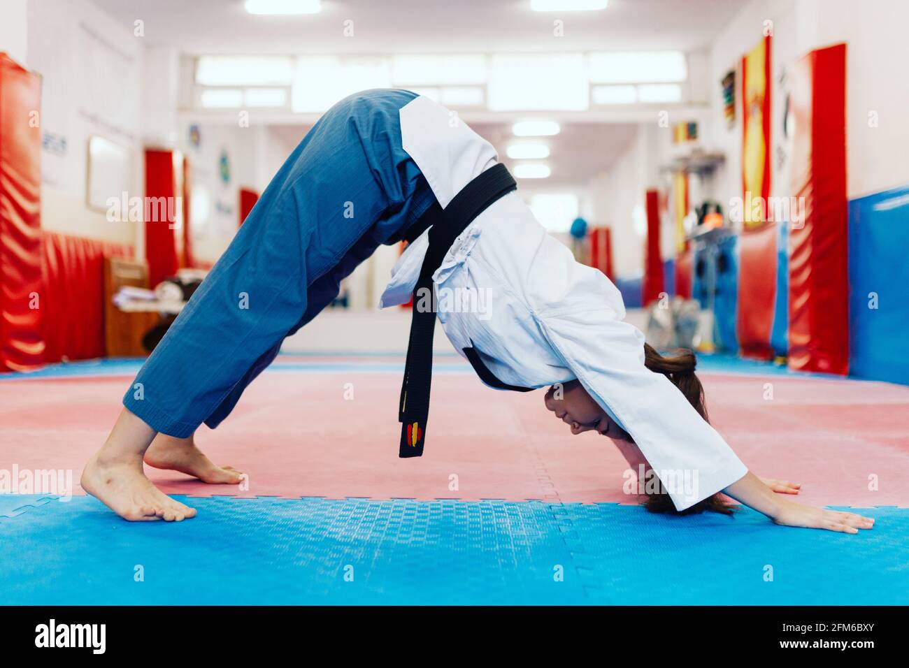 Young woman stretching in a dojo wearing taekwondo dobok Stock Photo ...