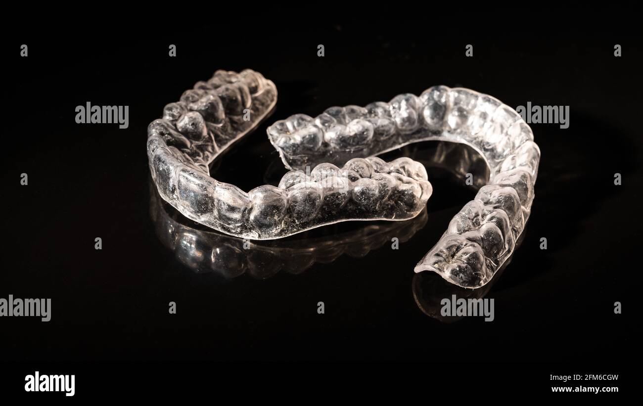 Removable plastic retainers for bite correction on a black background ...