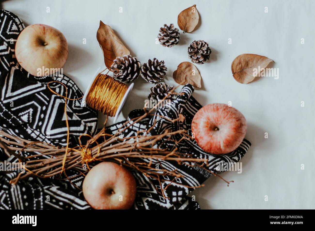 Top view of apples with decorative pines, thread, and tree branches on ...