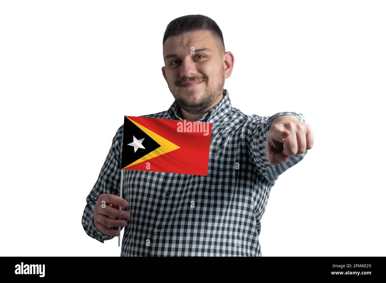 White guy holding a flag of East Timor and points forward in front of ...