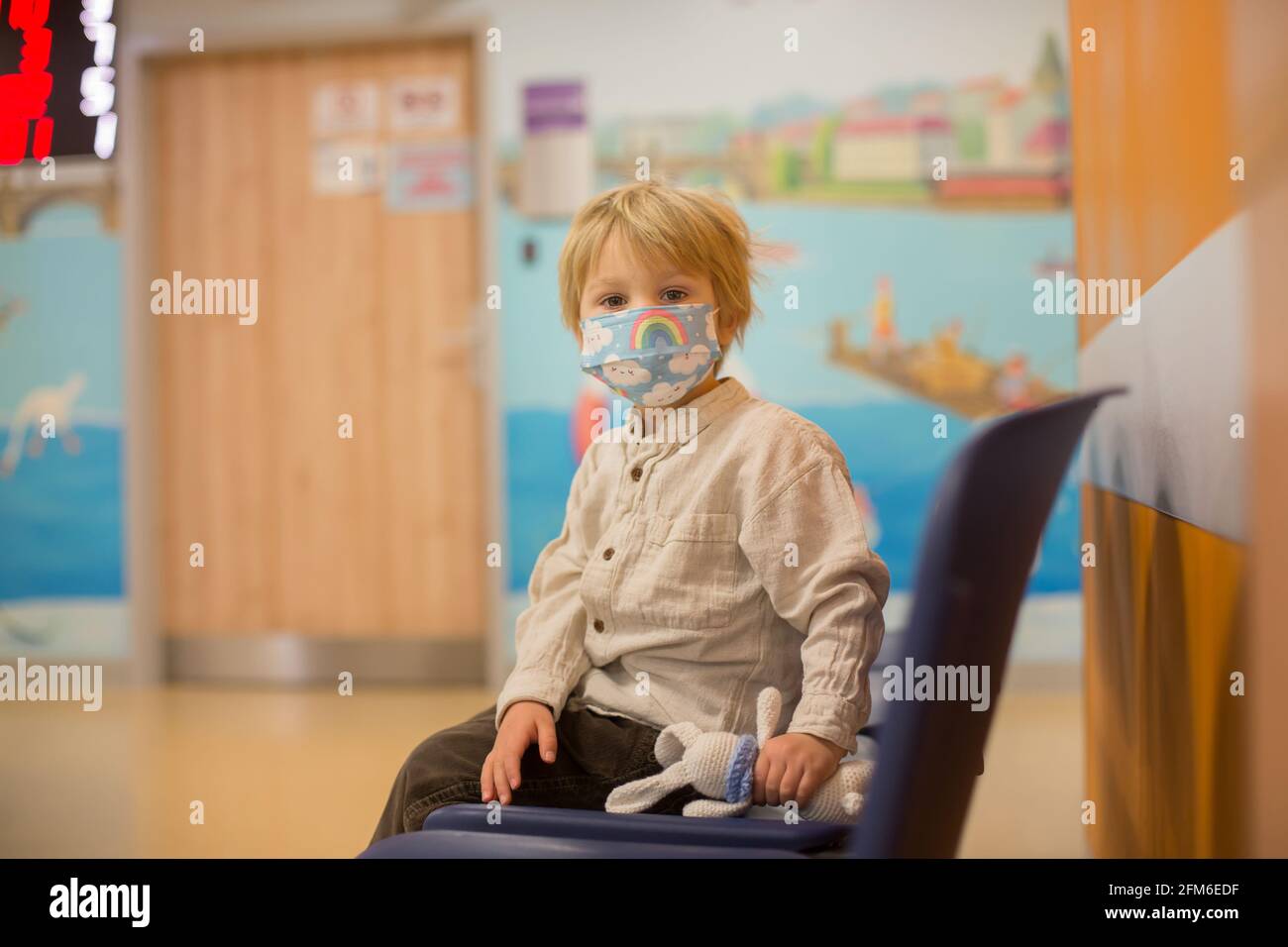 Child, boy, sitting in the waiting room in emergency, waiting for ...