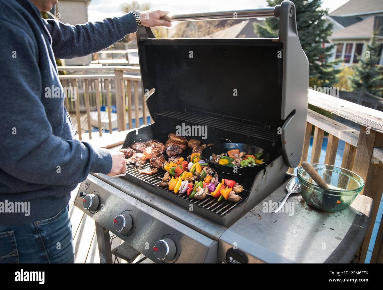 Man grilling chicken and vegetables outdoors on a gas bbq grill Stock ...