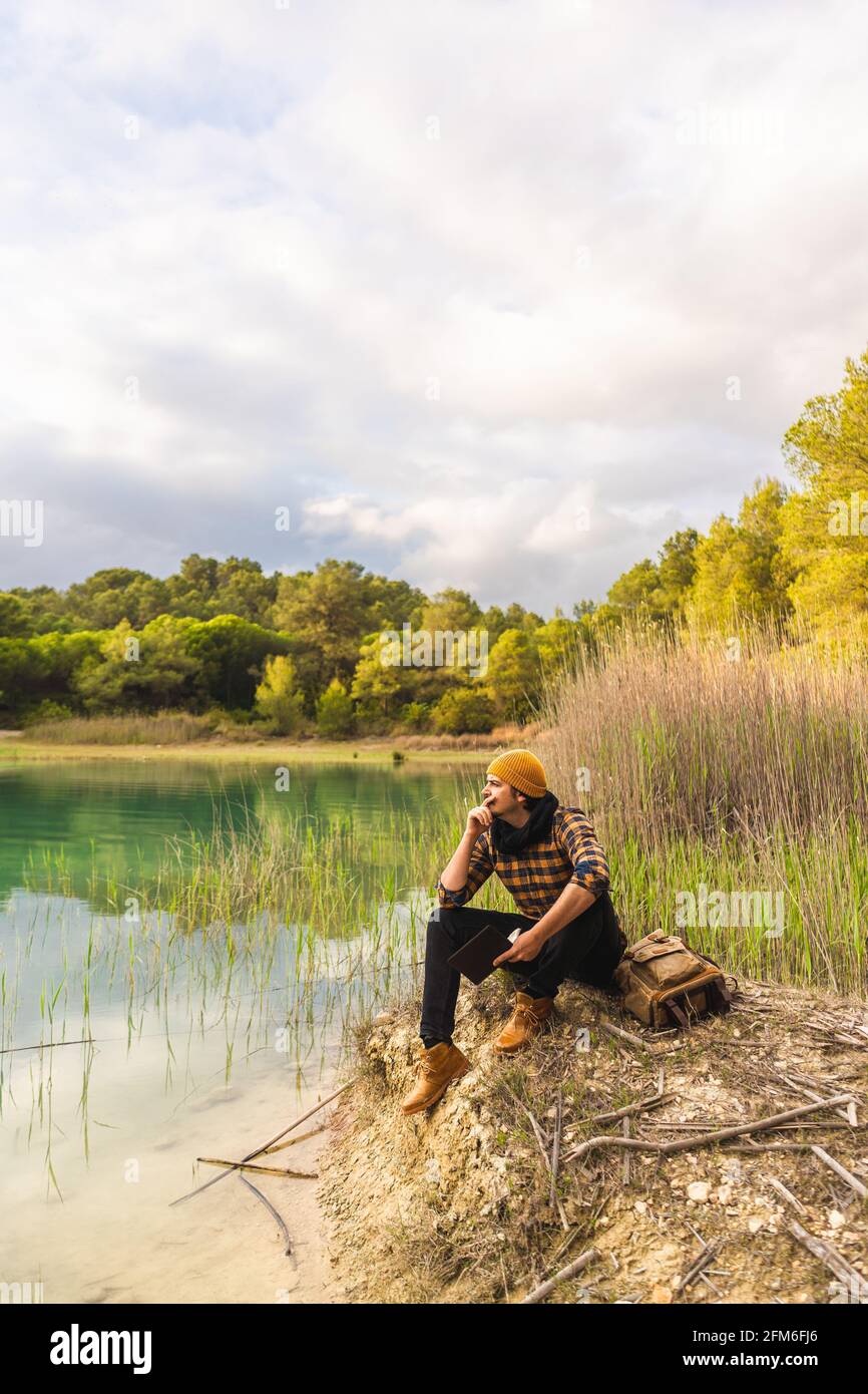 traveler contemplating beautiful scenery sitting looking at the lake ...