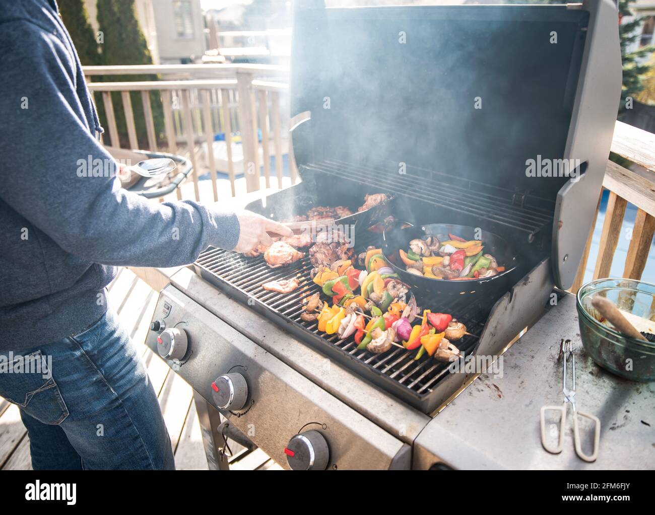 Man grilling chicken and vegetables outdoors on a gas bbq grill Stock ...