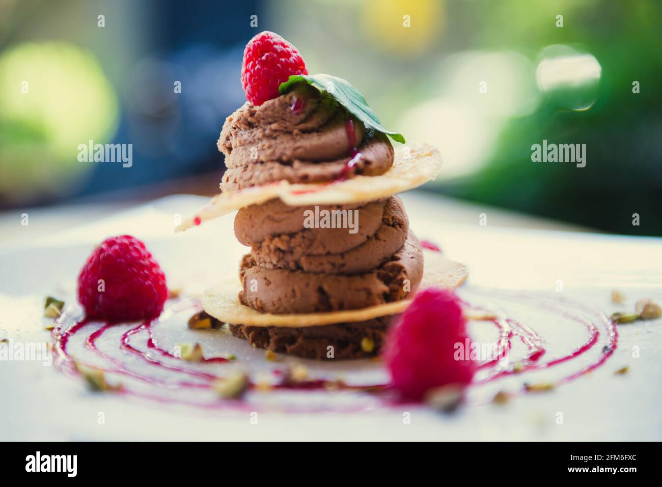 Chocolate mousse dessert with puff pastry and raspberries in restauran ...