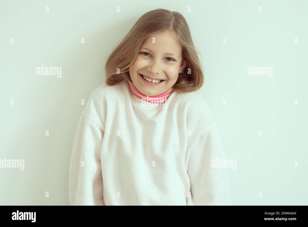 Shy cute teen girl with nice smile and eyes standing on white ...